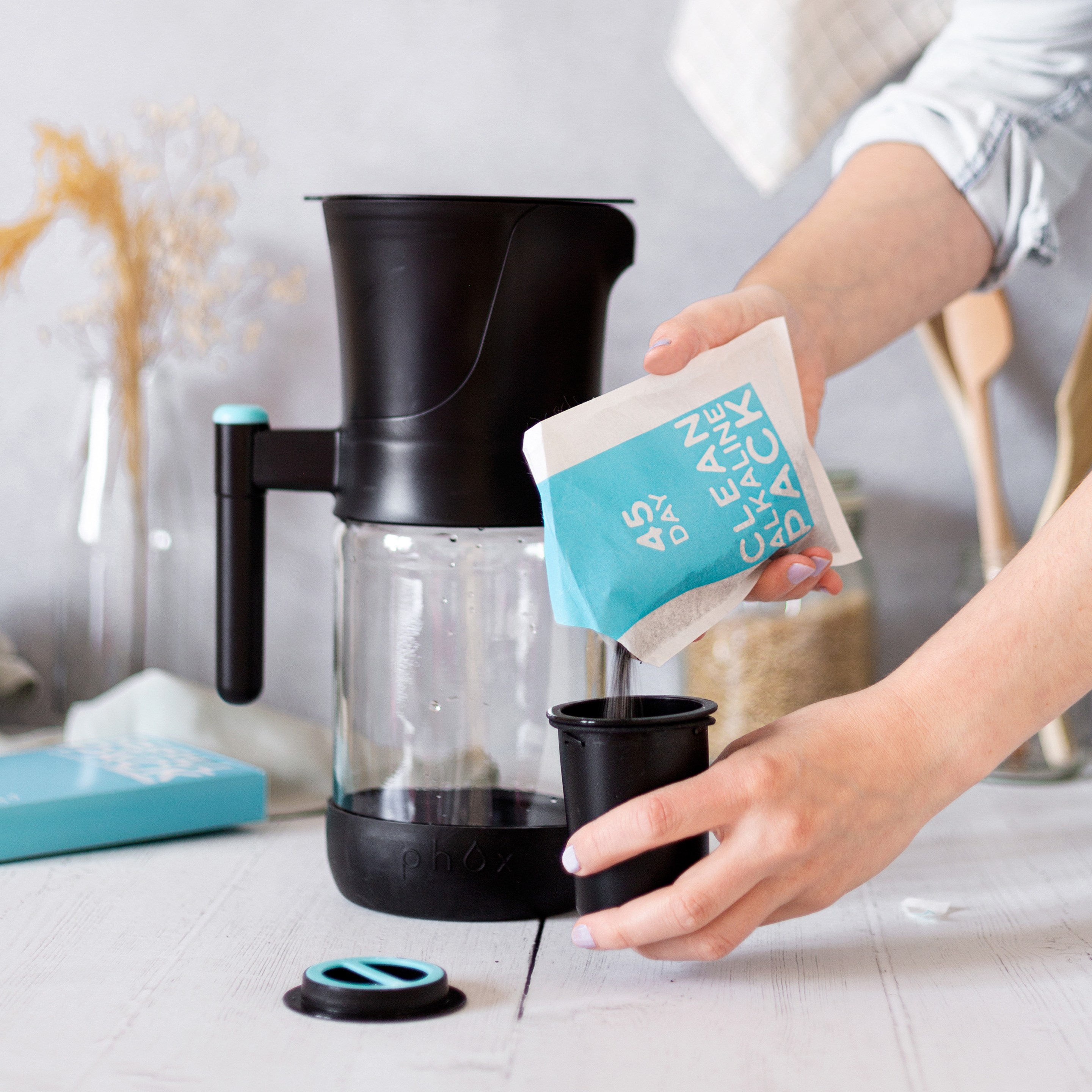 A sleek, modern glass pitcher with a refillable filter cartridge that ...